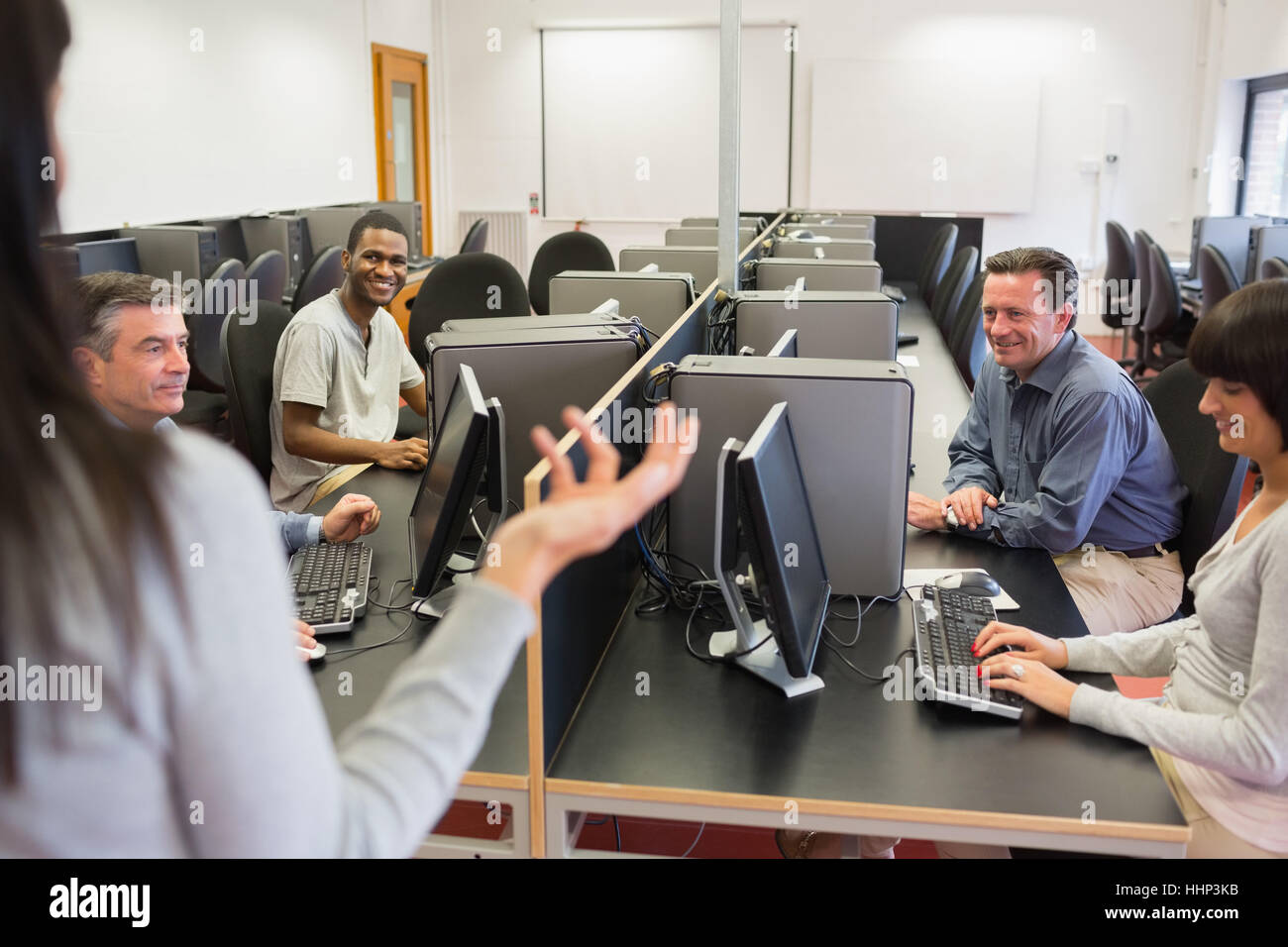 Teacher talking to group in computer room in college Stock Photo - Alamy