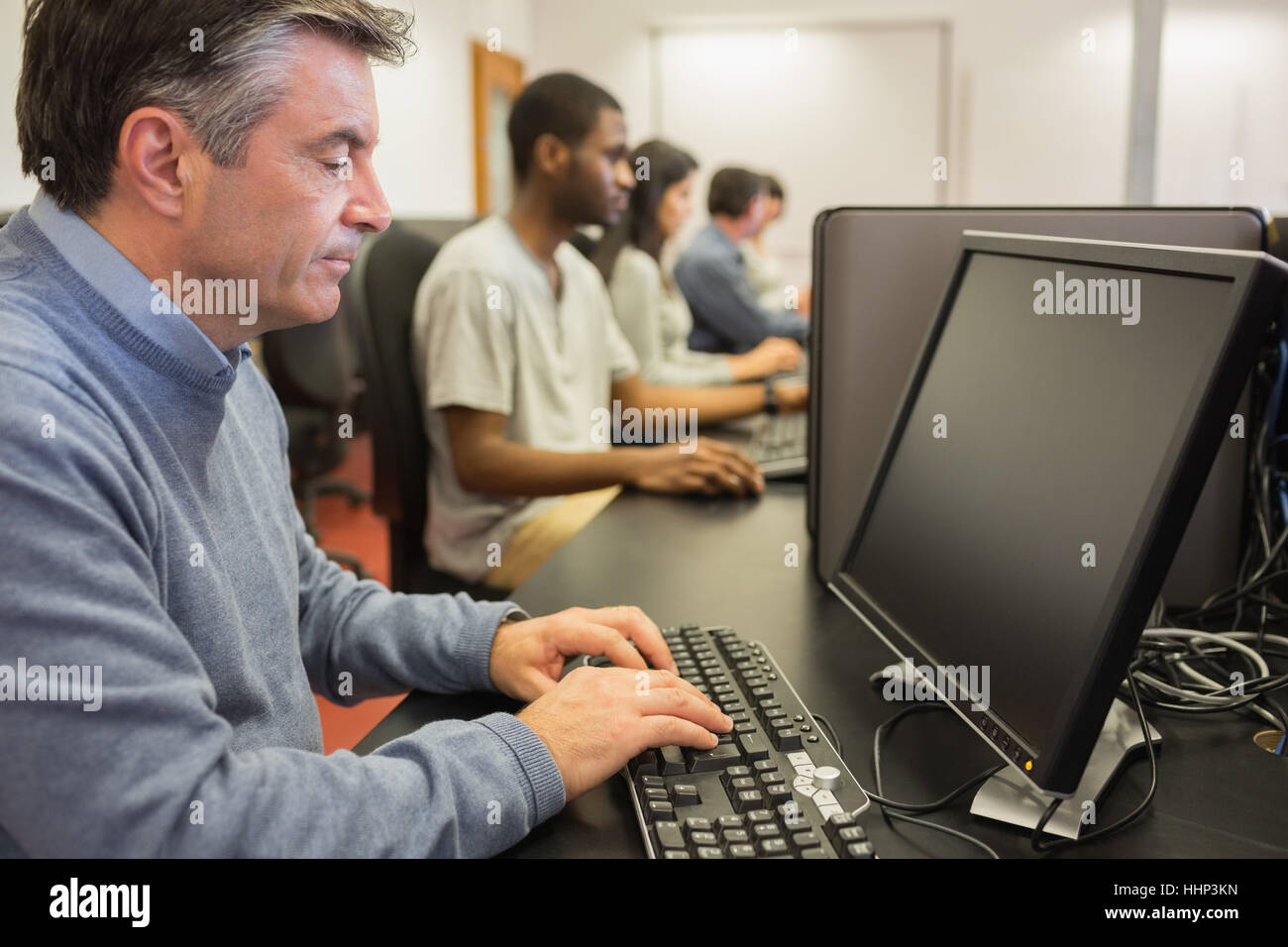 Man working at computer in computer class Stock Photo - Alamy
