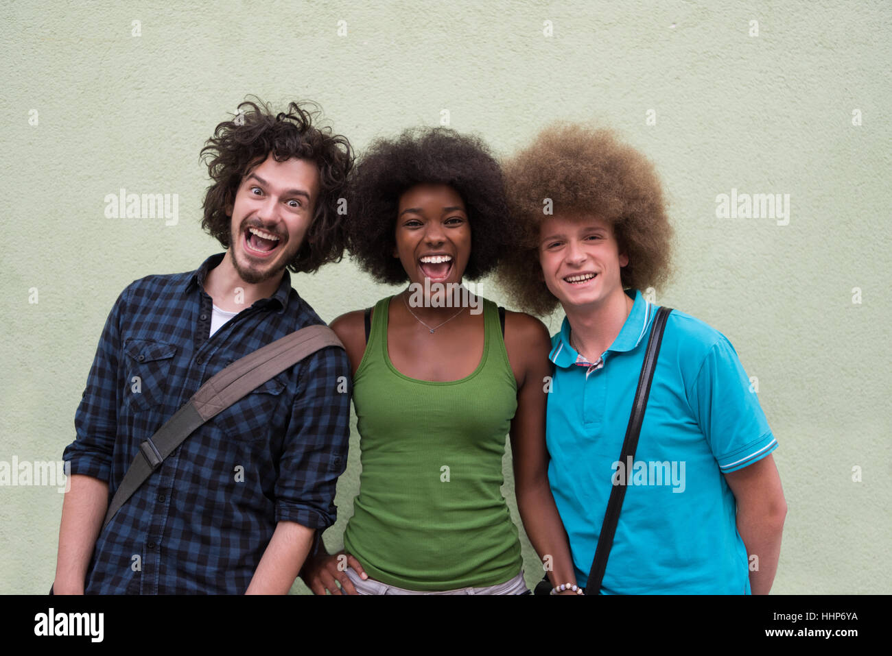 Portrait of multiethnic group of happy three friends in casual wear ...