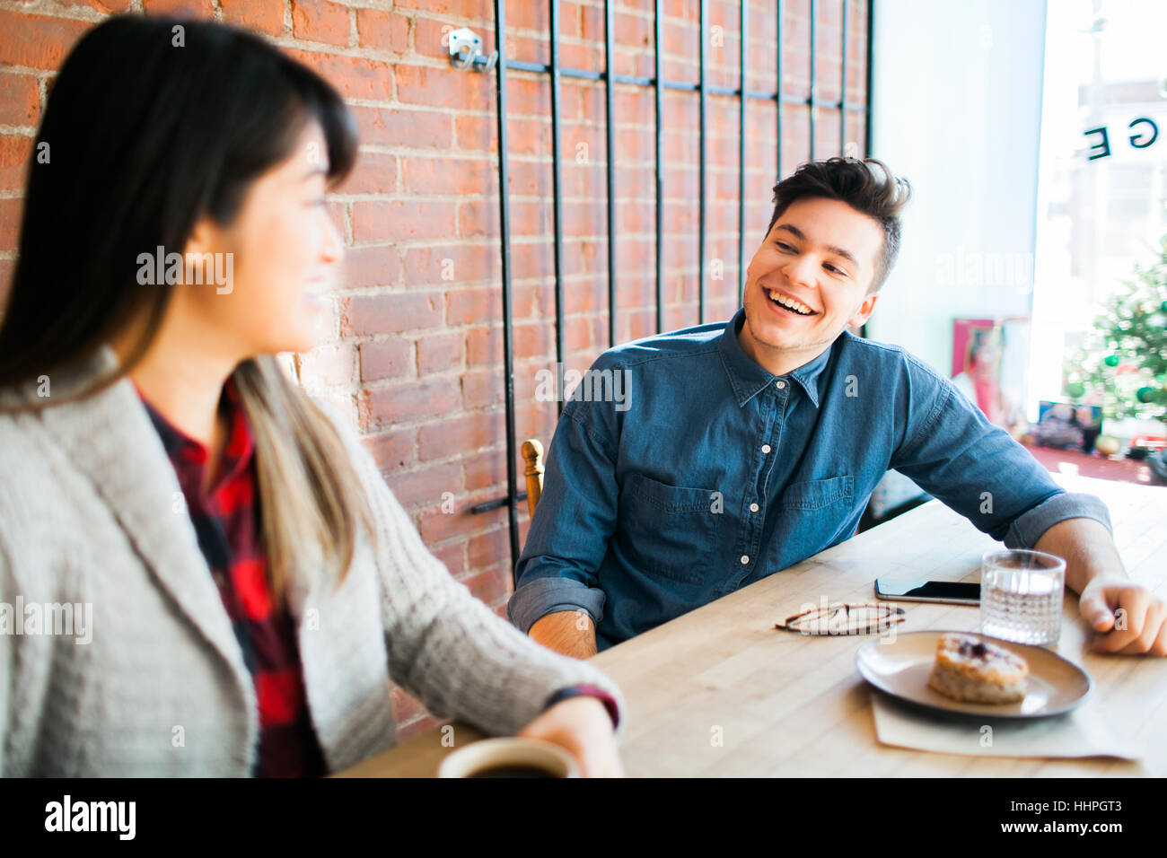 Young couple chatting in a coffee shop Stock Photo - Alamy