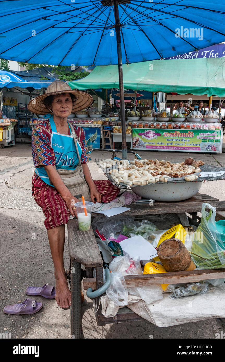 A barefoot woman cooks food on a grill in a table which is powered by a ...