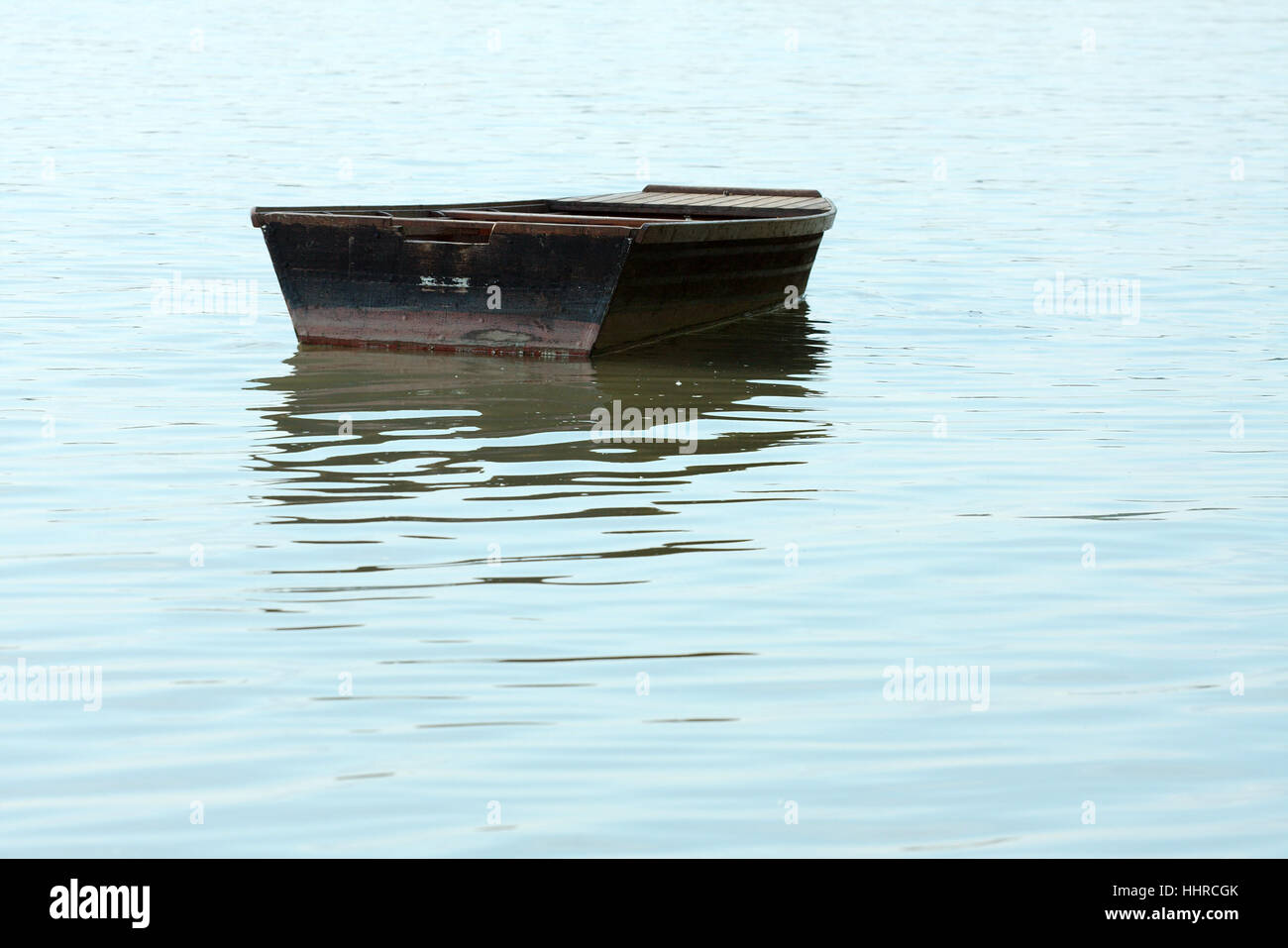 Old, empty boat floating on the water surface Stock Photo - Alamy
