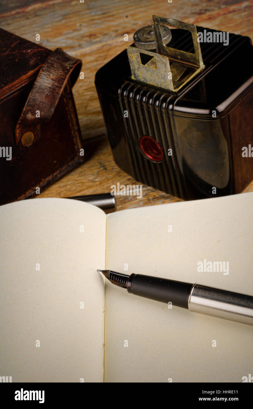 Still life with vintage camera, fountain pen and notebook, a journalism ...