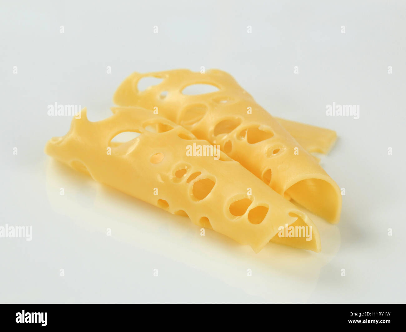 Thin slices of Swiss cheese - studio Stock Photo - Alamy