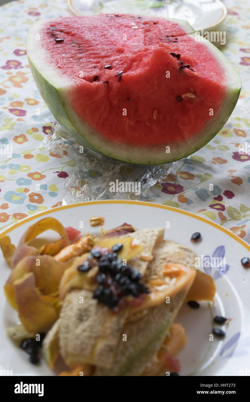 watermelon and leftovers after the lunch on a set table Stock Photo - Alamy