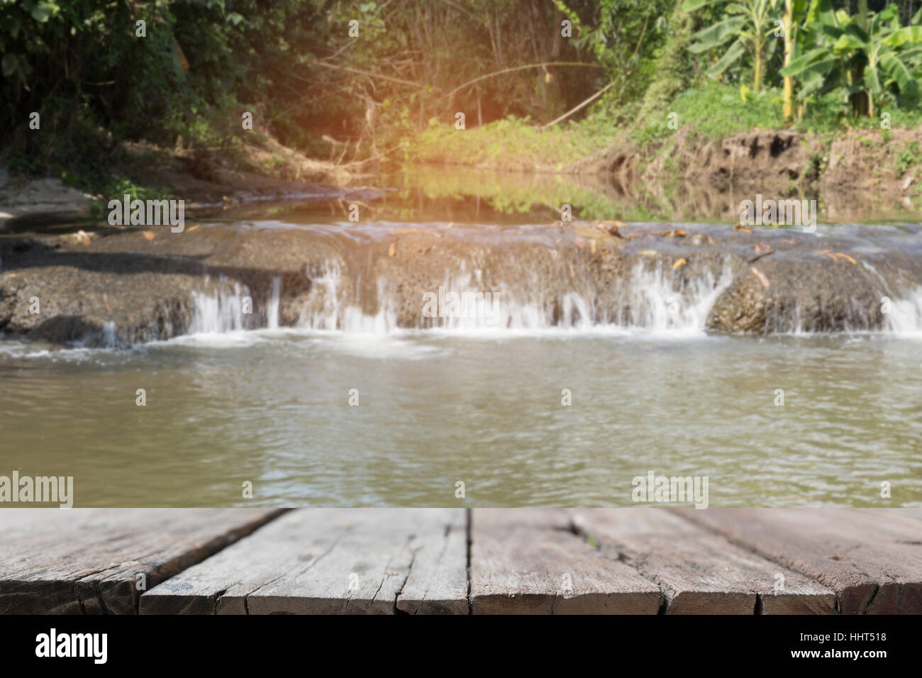 wood table for montage or display your product with background of waterfall and running water ...