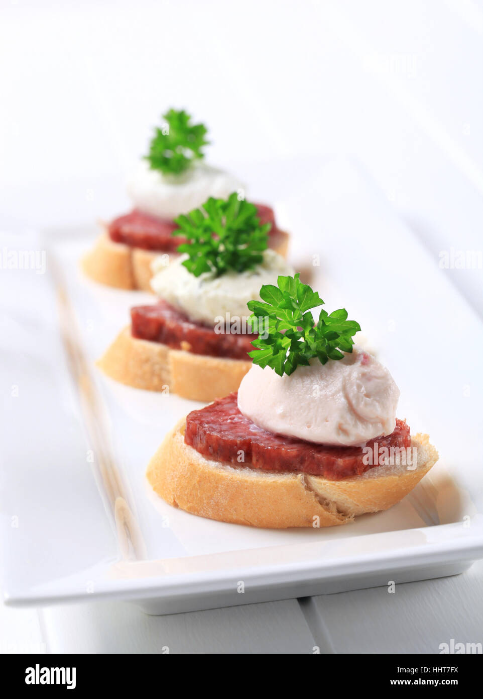 Canapes with spicy salami and savory spread Stock Photo - Alamy