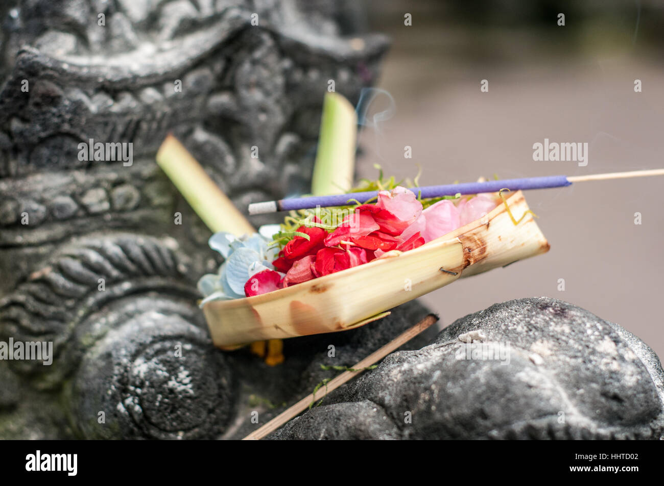 Religious offerings on top of a stone statue Stock Photo - Alamy