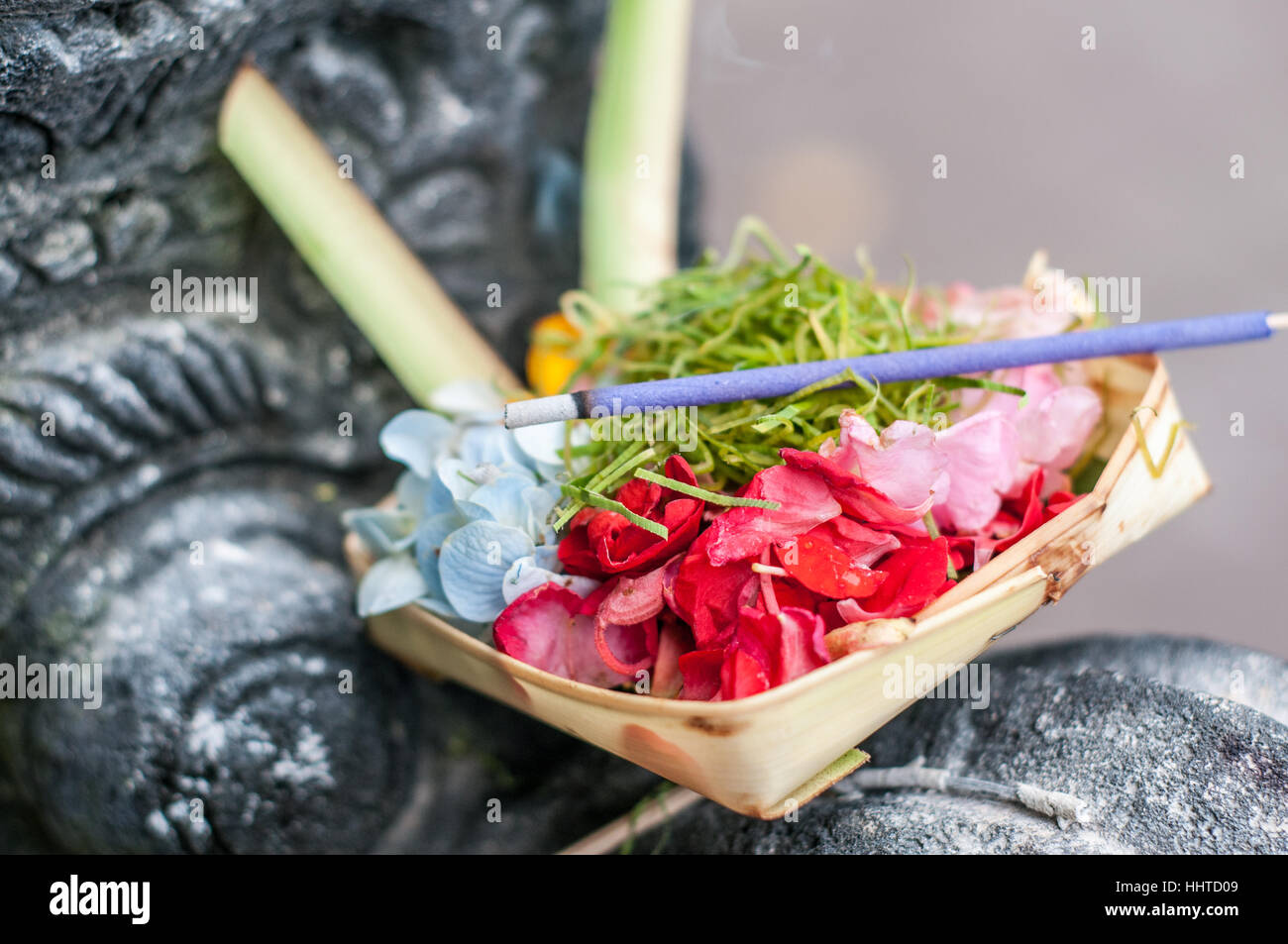 Religious offerings on top of a stone statue Stock Photo - Alamy