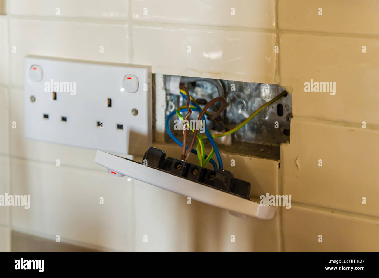 Domestic twin plug electrical socket unscrewed from the wall for repair ...