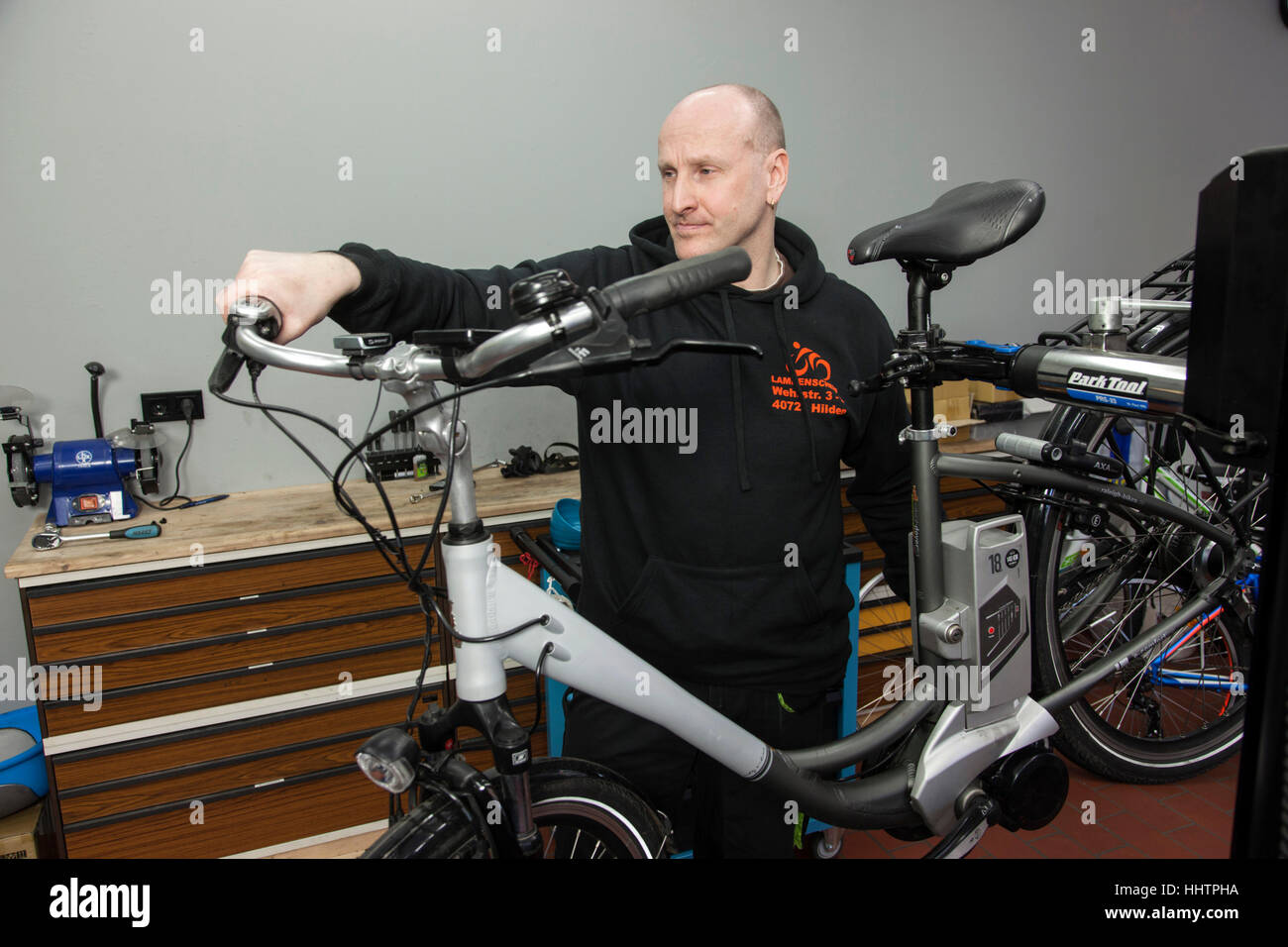 A bicycle mechanic during the inspection at a e-bike in his workshop ...