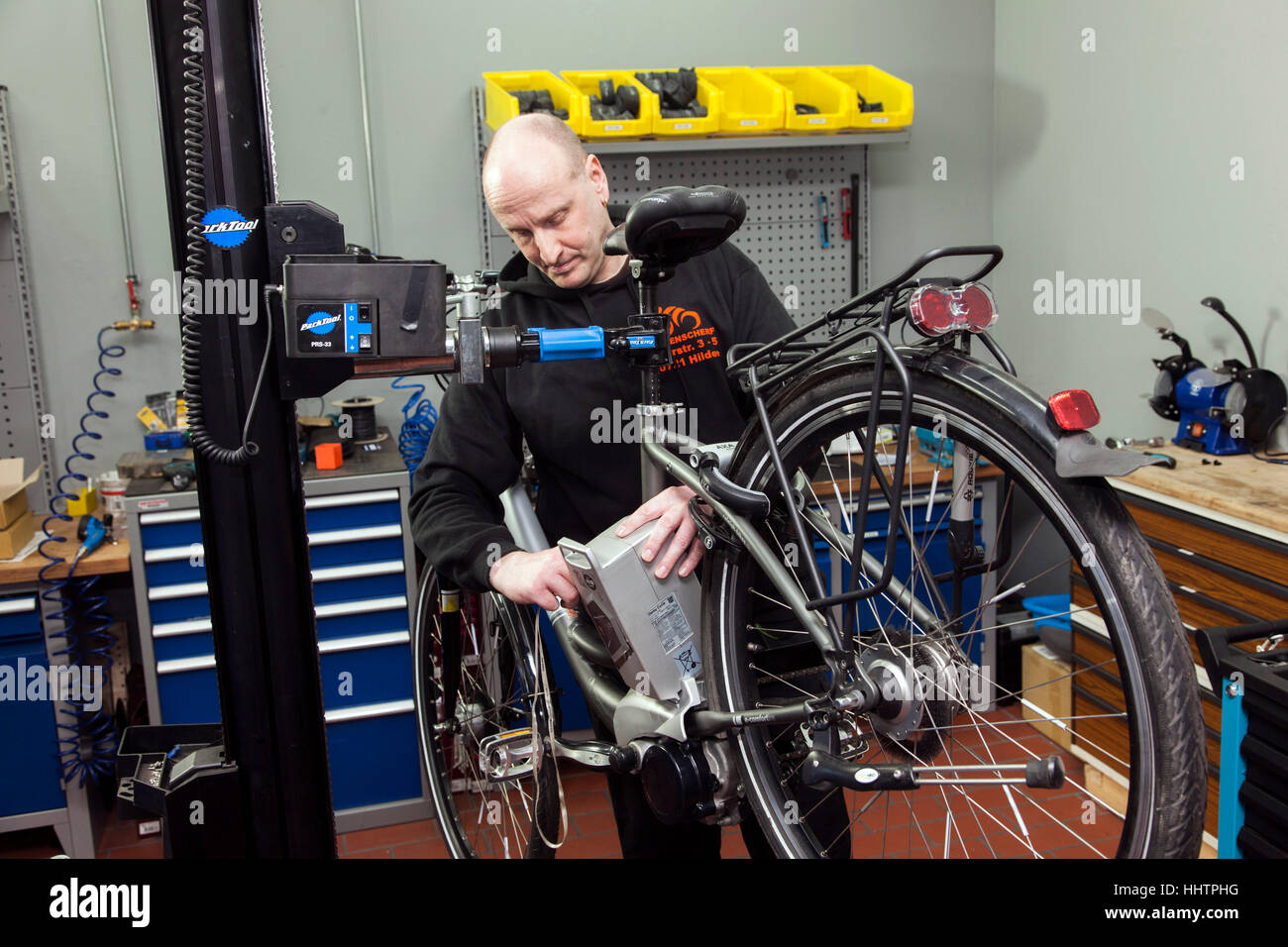 A bicycle mechanic during the inspection at a e-bike in his workshop ...