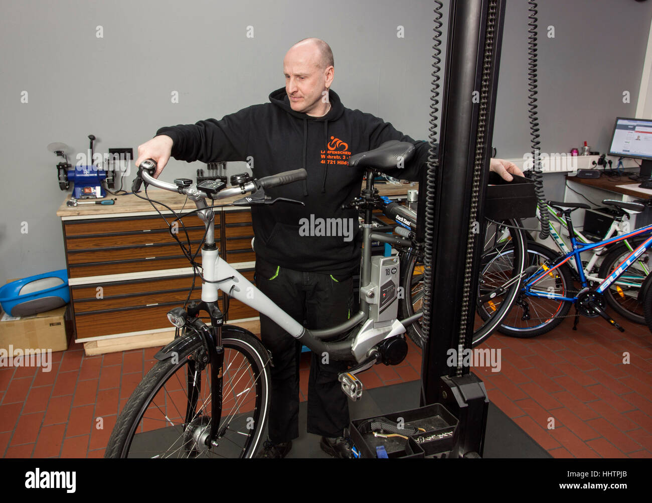 A bicycle mechanic during the inspection at a e-bike in his workshop ...