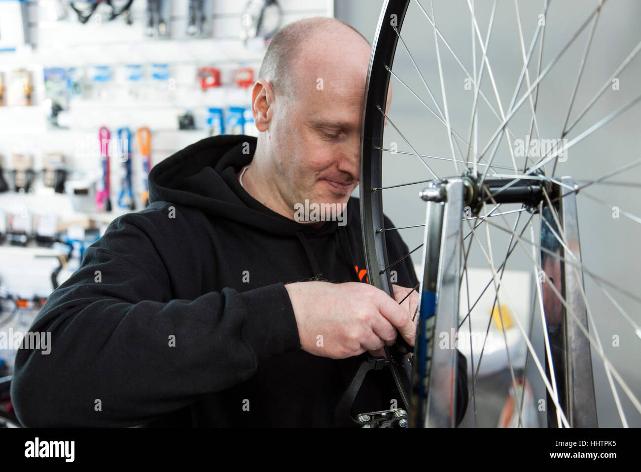 A bicycle mechanic centering a rear wheel in his workshop Stock Photo ...