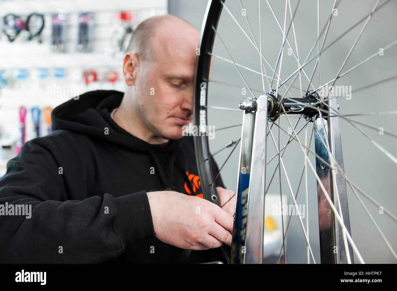 A bicycle mechanic centering a rear wheel in his workshop Stock Photo ...