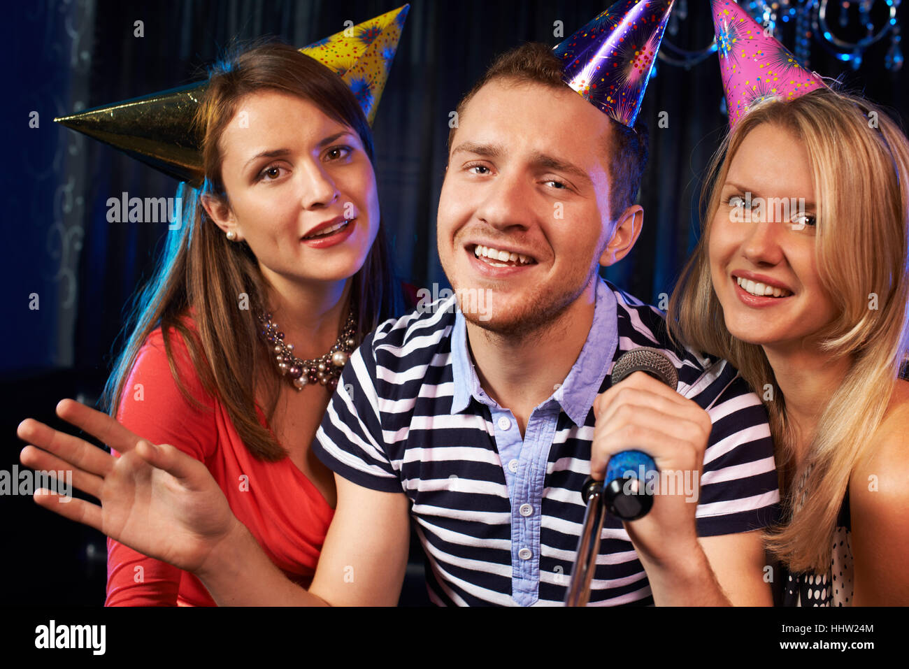 Portrait of happy people singing in microphone in the karaoke bar Stock ...