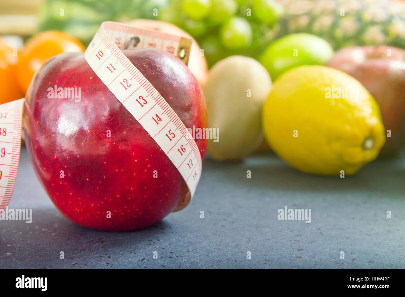 Apple and measuring tape over fruity background Stock Photo - Alamy