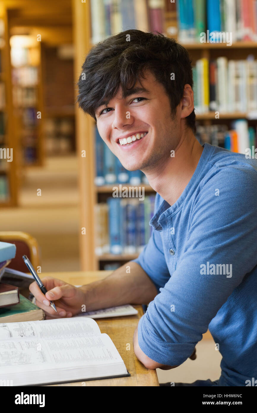 Student sitting at the library smiling Stock Photo - Alamy
