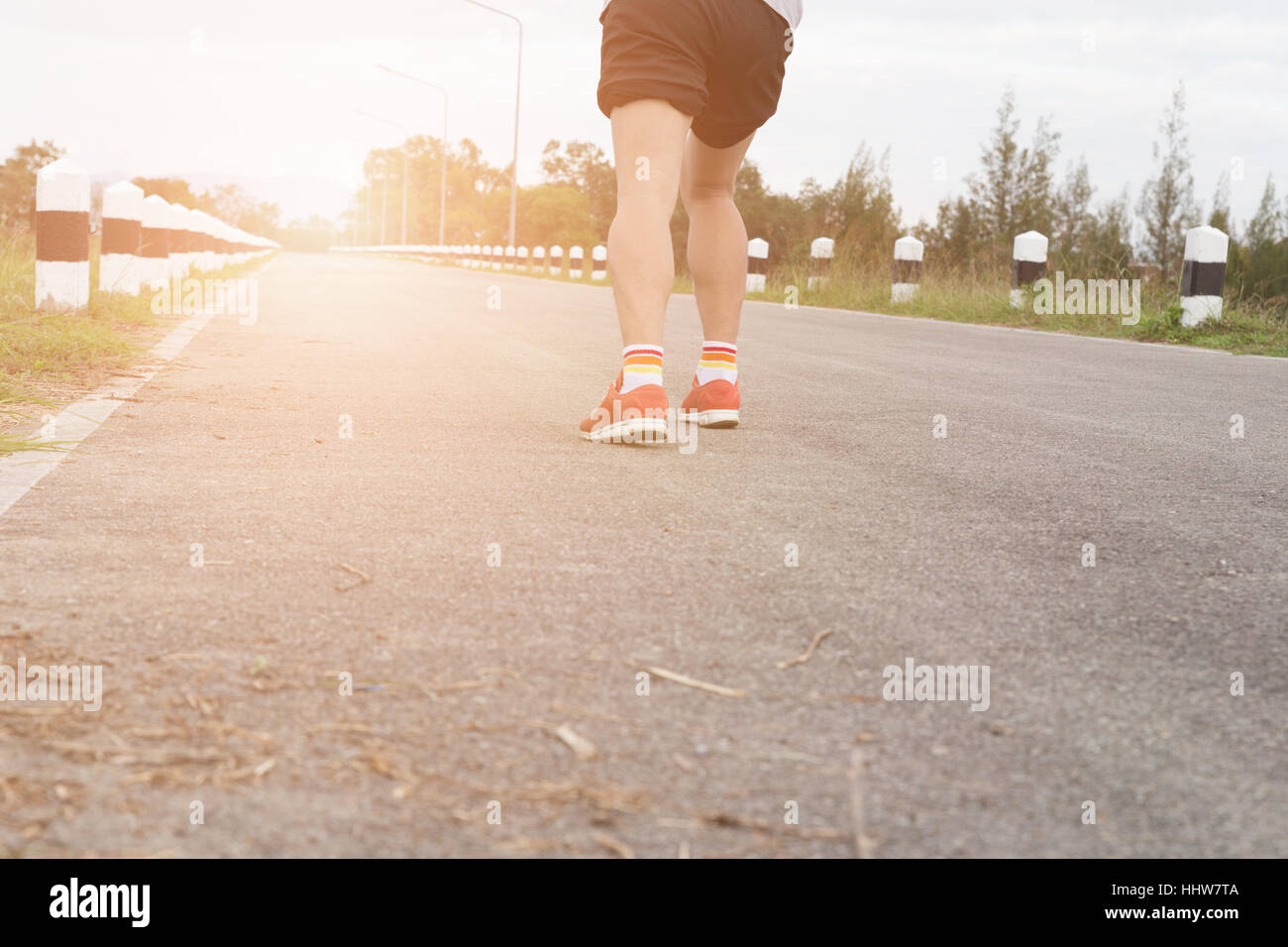 athletic young man jogging, running on road in the park. Healthy ...