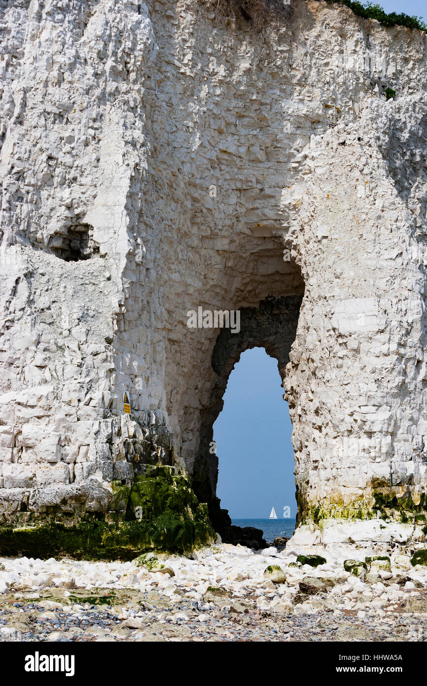 Kingsgate Bay, Margate, Kent. A sailing boat is framed by Kingsgate ...