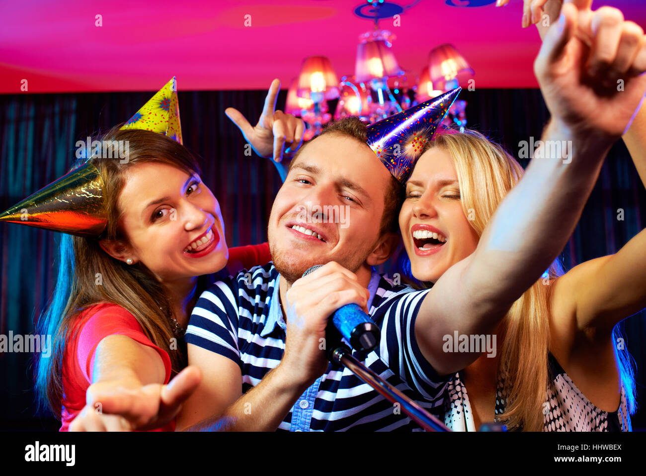 Portrait of happy people singing in microphone in the karaoke bar Stock ...