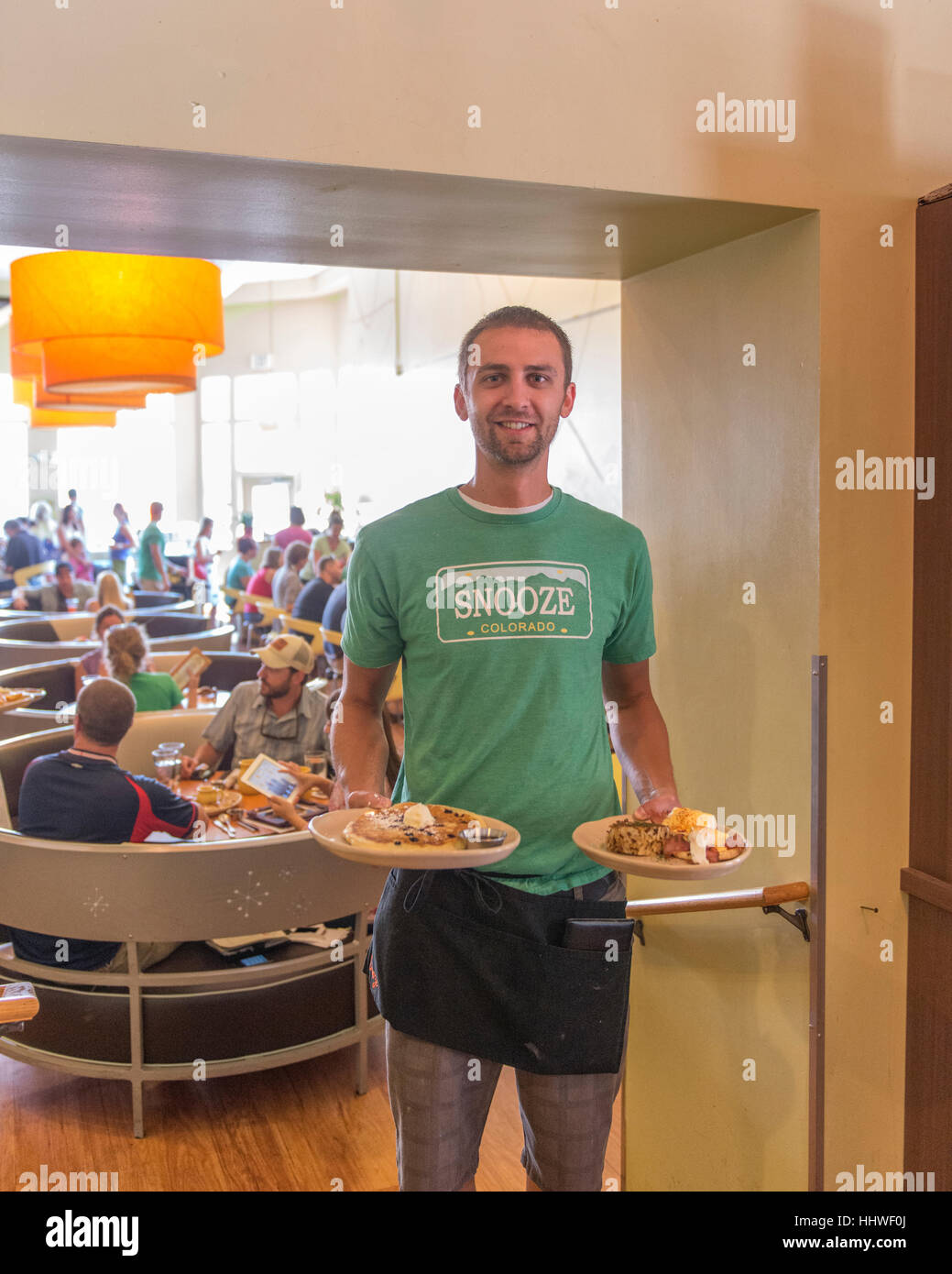 Waiter holding American breakfasts at Snooze an AM Eatery. Denver ...