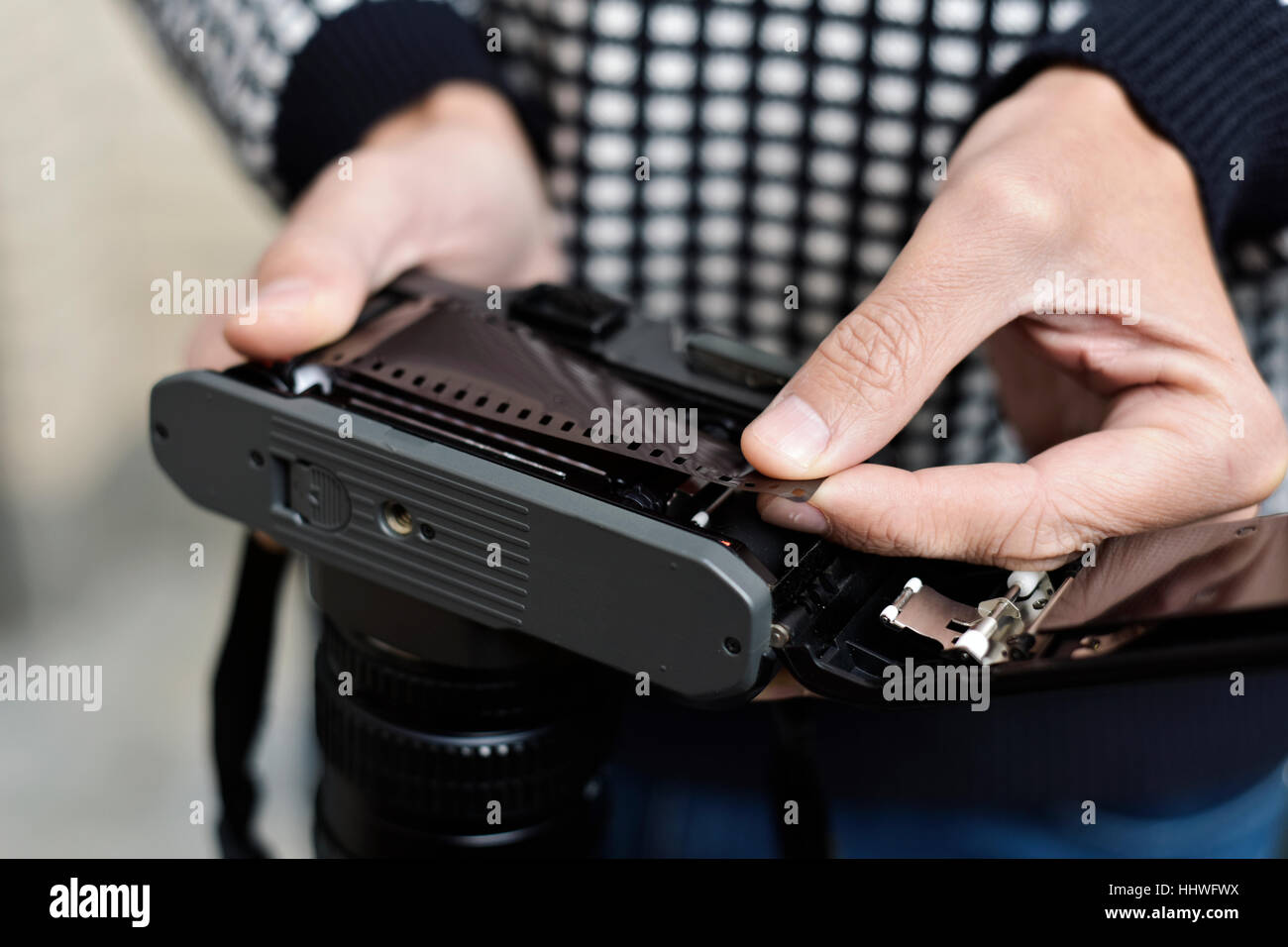 closeup of a young caucasian man changing the roll film of his camera ...