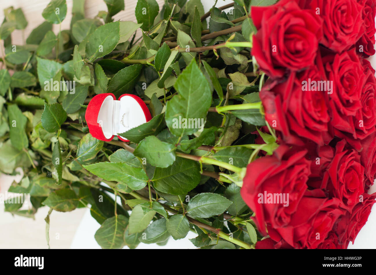 bouquet-of-red-roses-with-an-engagement-ring-in-a-heart-shaped-box-on