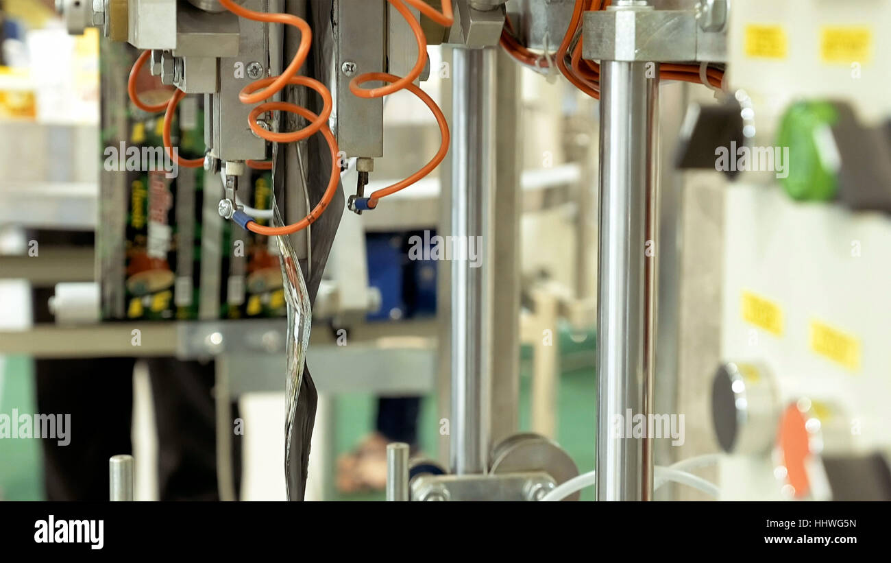 Food factory packing machine with pipes and rolls Stock Photo - Alamy