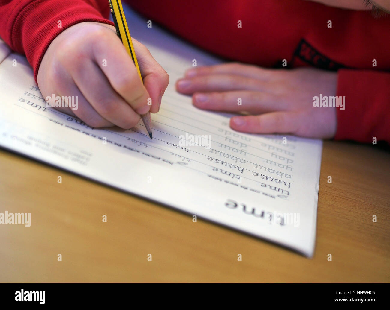 primary school child writing in an exercise book Stock Photo - Alamy