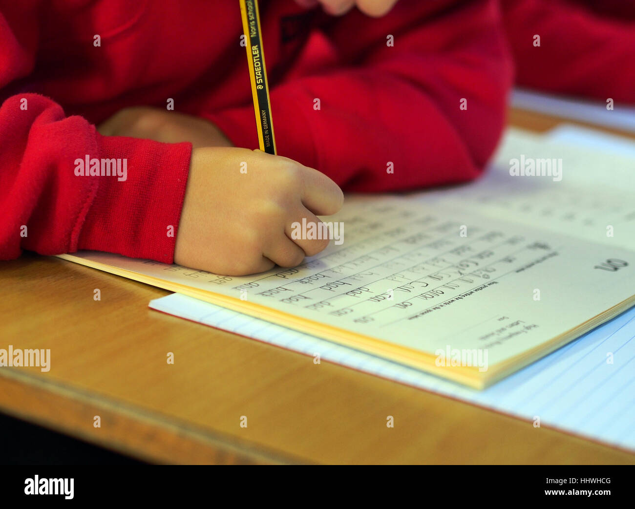 primary school child writing in an exercise book Stock Photo - Alamy