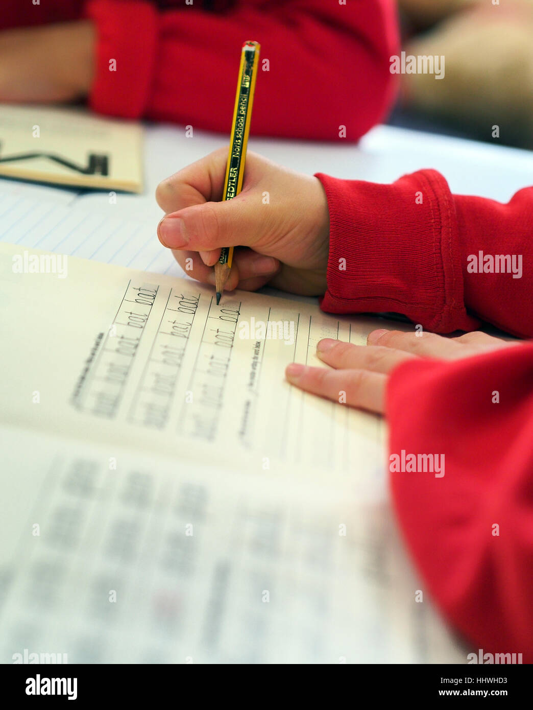 primary school child writing in an exercise book Stock Photo - Alamy