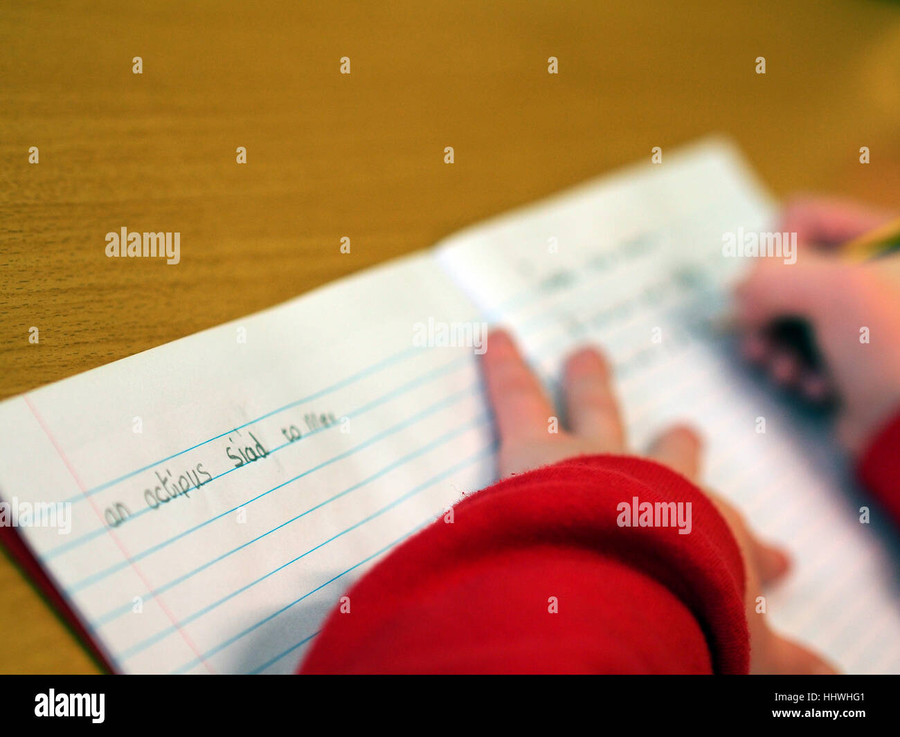 primary school child writing in an exercise book Stock Photo - Alamy