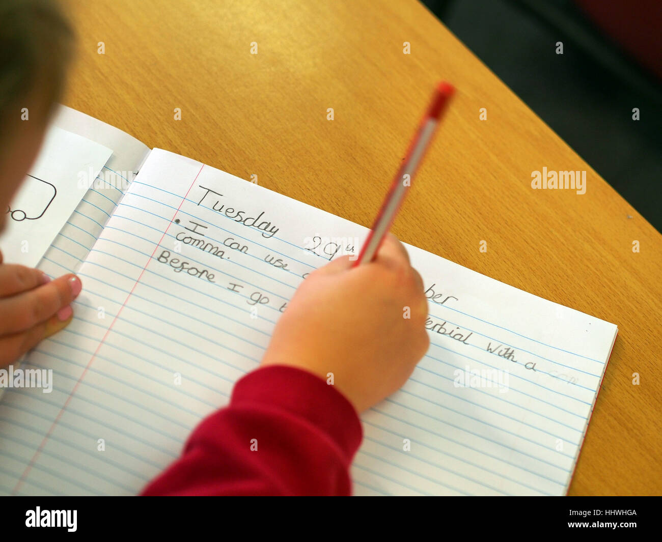 primary school child writing in an exercise book Stock Photo - Alamy