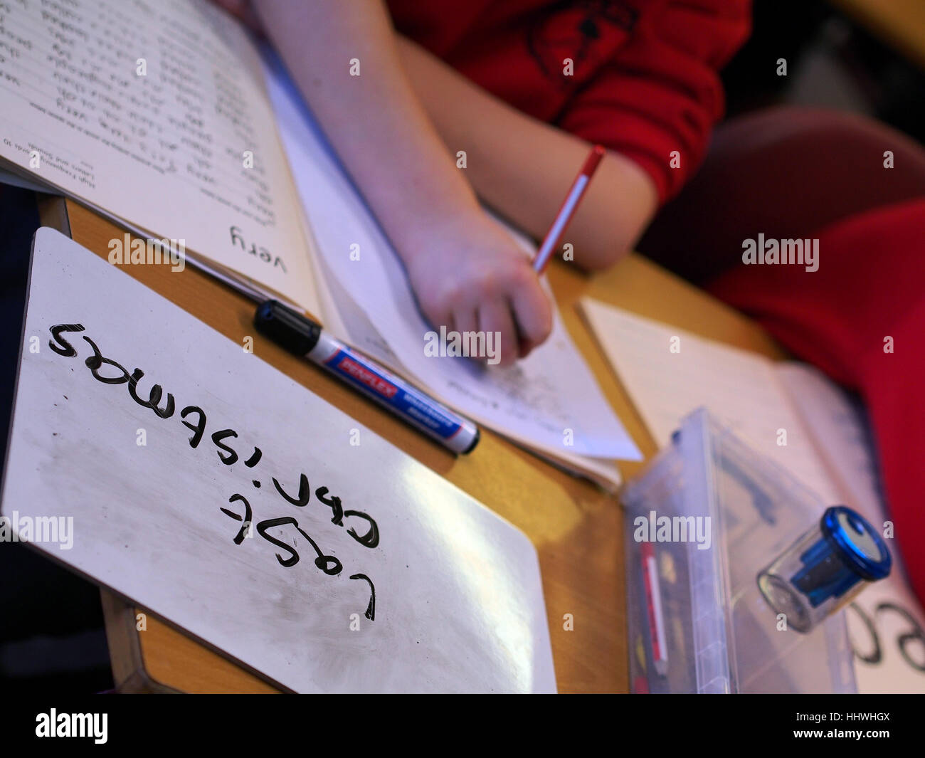 primary school child writing in an exercise book Stock Photo - Alamy