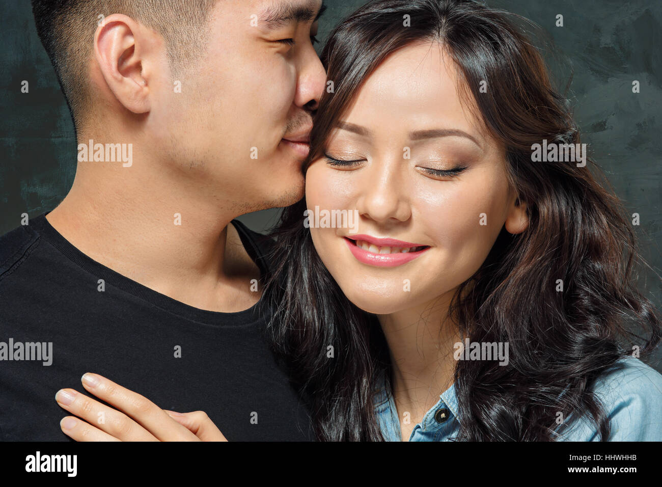 Portrait of smiling Korean couple on a gray studio background Stock ...