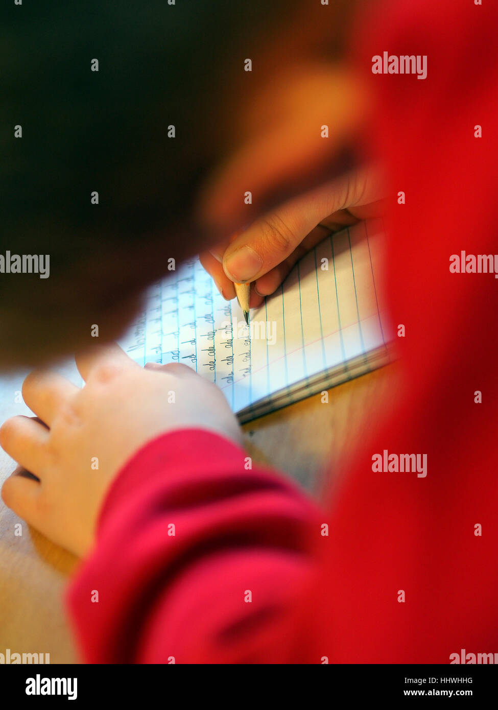 primary school boy writing in exercise book Stock Photo - Alamy