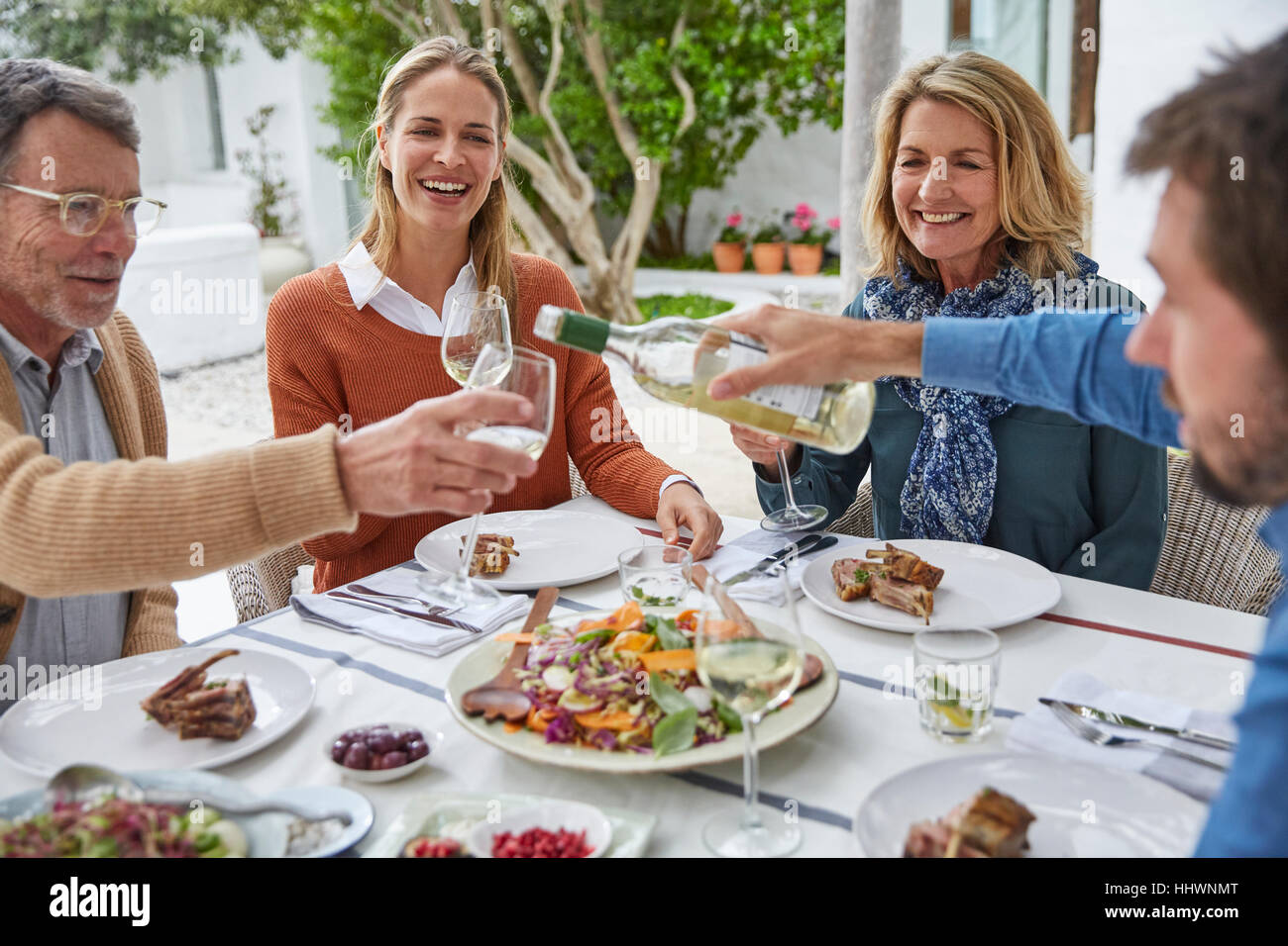 Couples drinking white wine and eating lunch on patio Stock Photo - Alamy