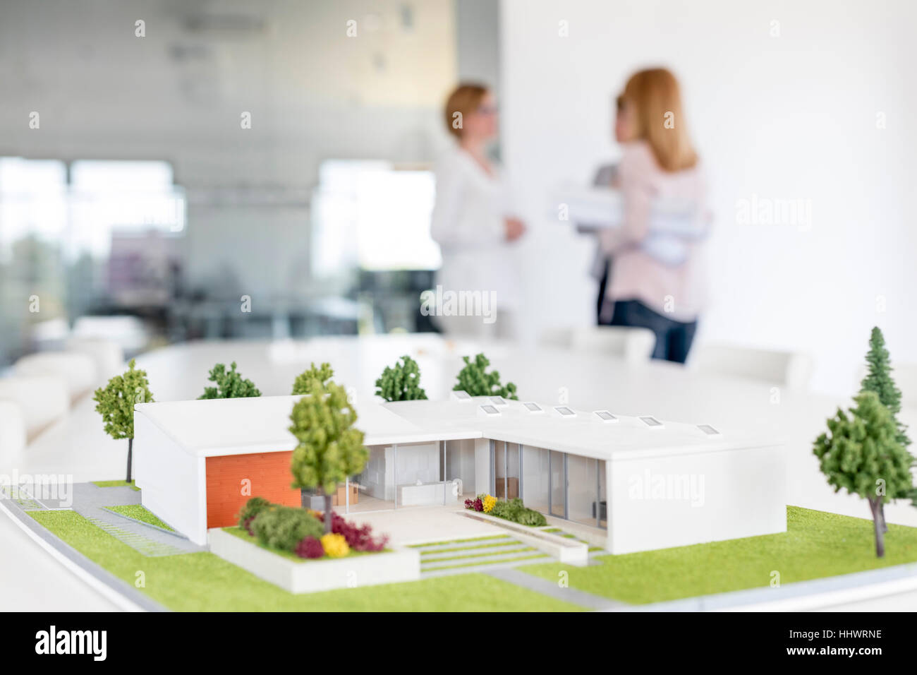 Female architects talking behind building model Stock Photo - Alamy