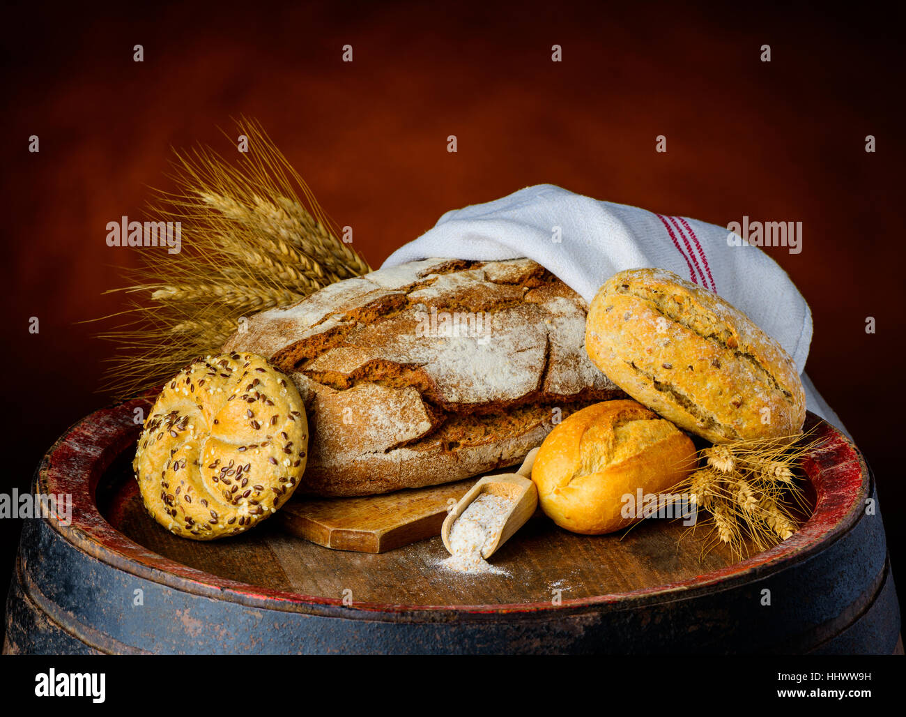 Bread, bun and cereal products on a wooden barrel on rustic background ...