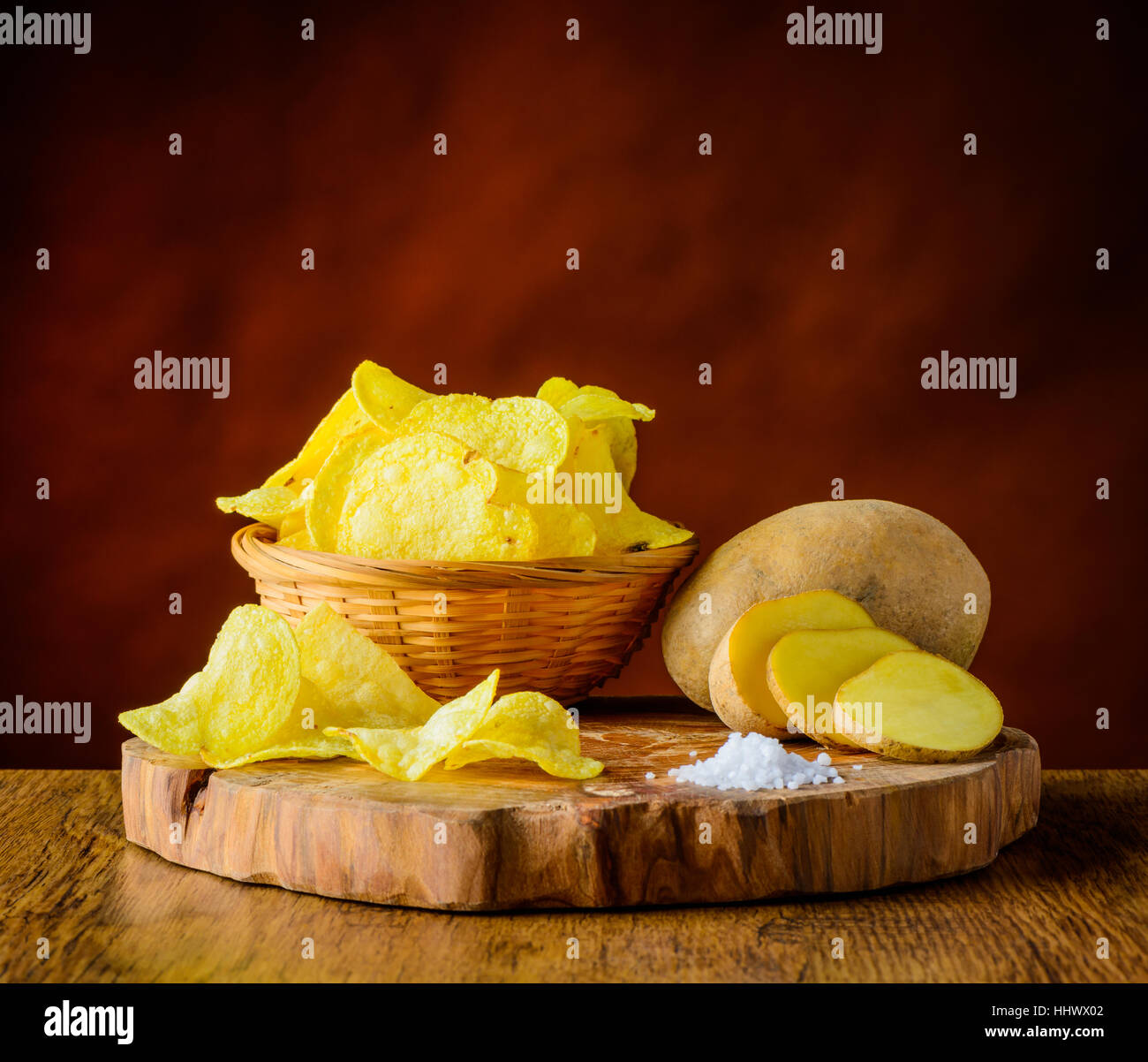Potato Chips on and potato in still life Stock Photo - Alamy