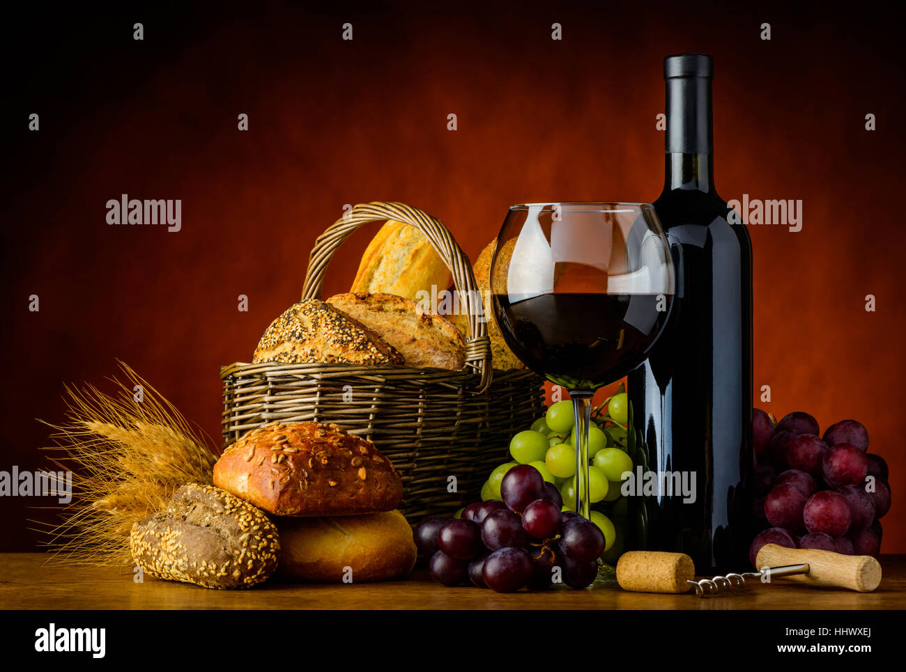 Glass and Bottle red wine with basket of bread in rustic still life ...