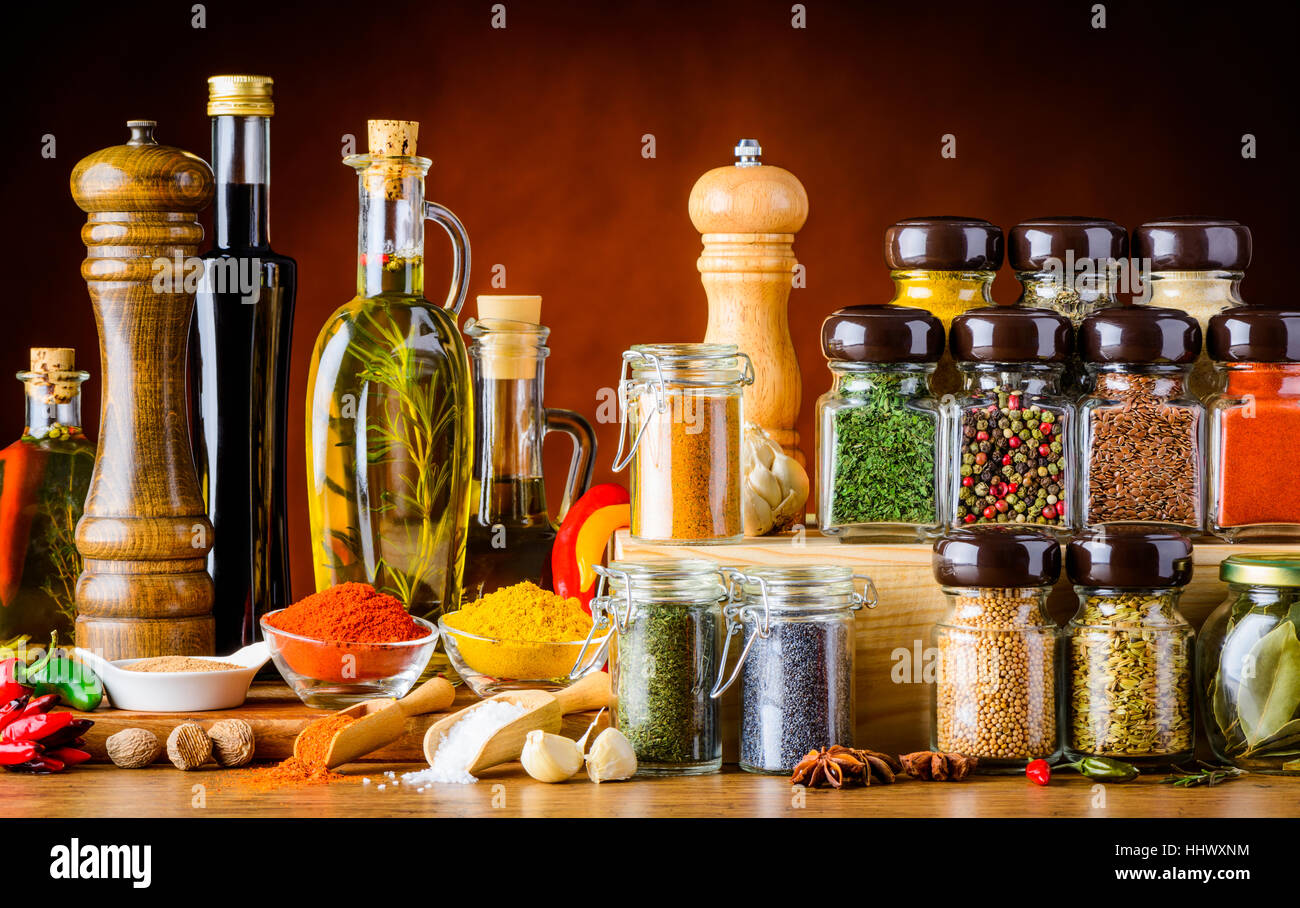Bottles of oil and Balsamic vinegar and different spices and seeds and ...
