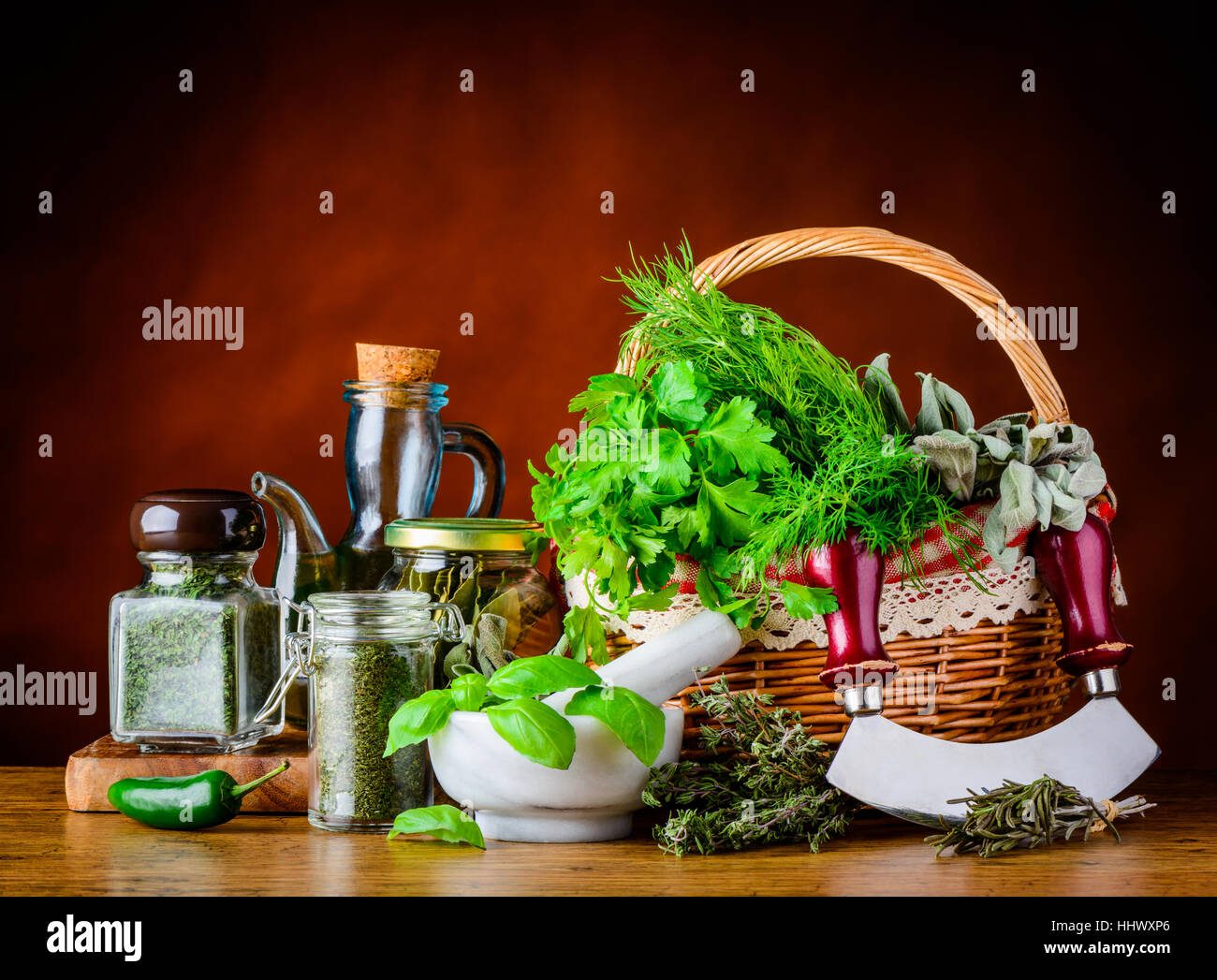 Fresh green Cooking Herbs in basket and dried cooking herbs in glasses ...