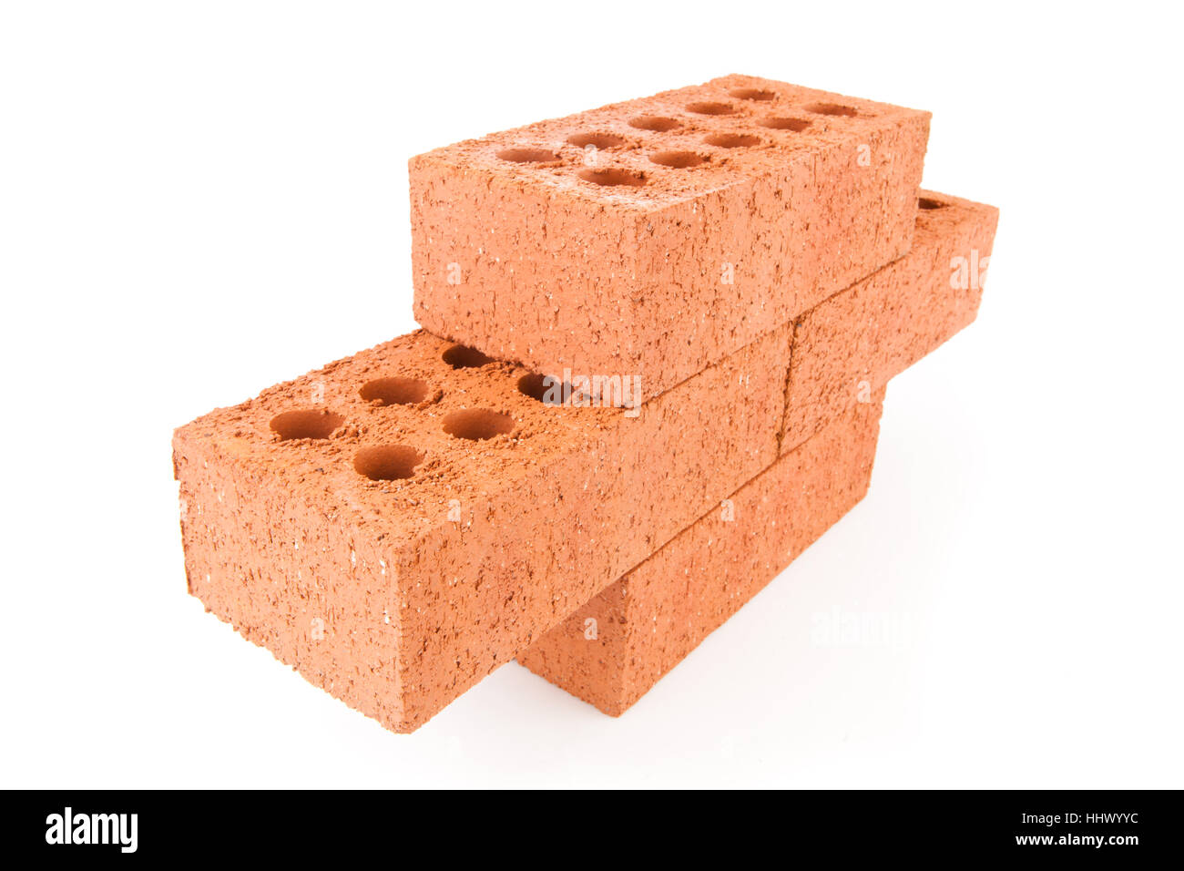 Four clay bricks stacked as a part of a wall against a white background ...