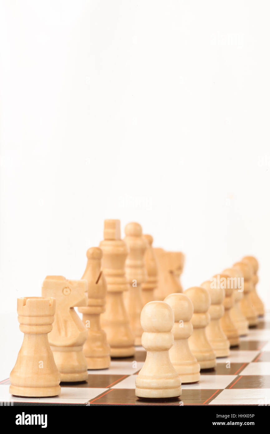 White chess pieces standing at the chessboard against white background ...