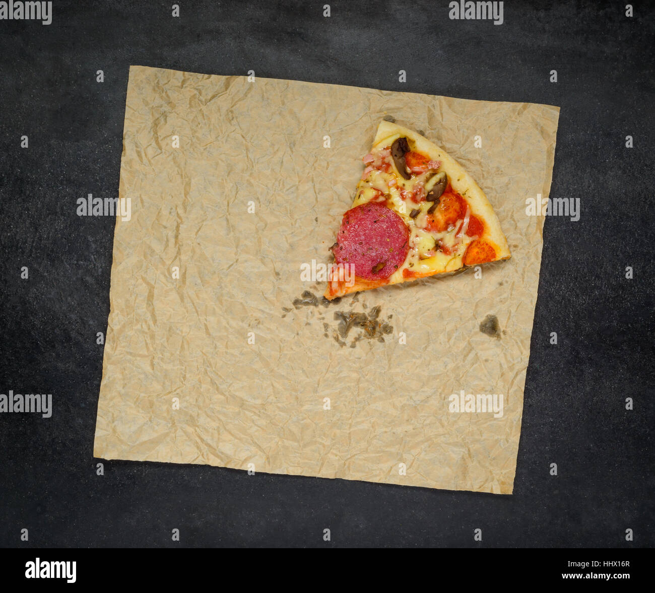 Only one Slice of Baked Junk Food Pizza left on a Paper Stock Photo - Alamy