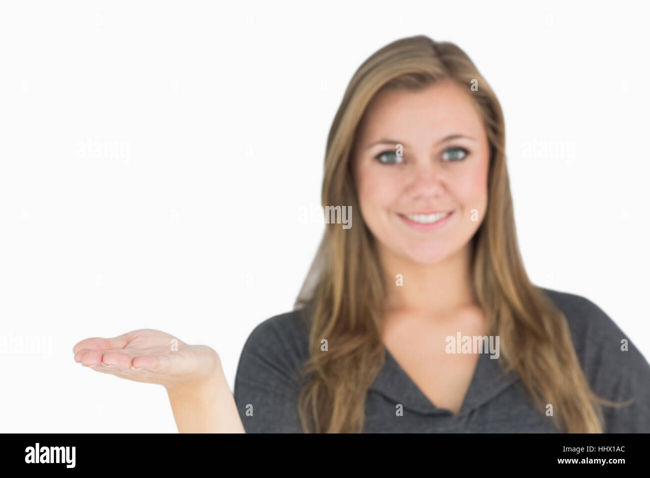 Blonde woman presenting with her hand in the white background Stock ...