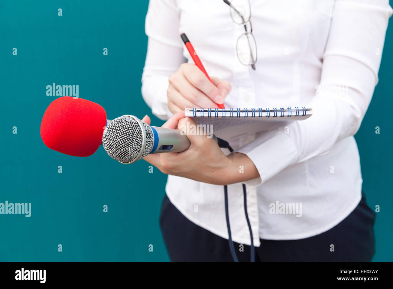 Female reporter taking notes at press conference Stock Photo - Alamy