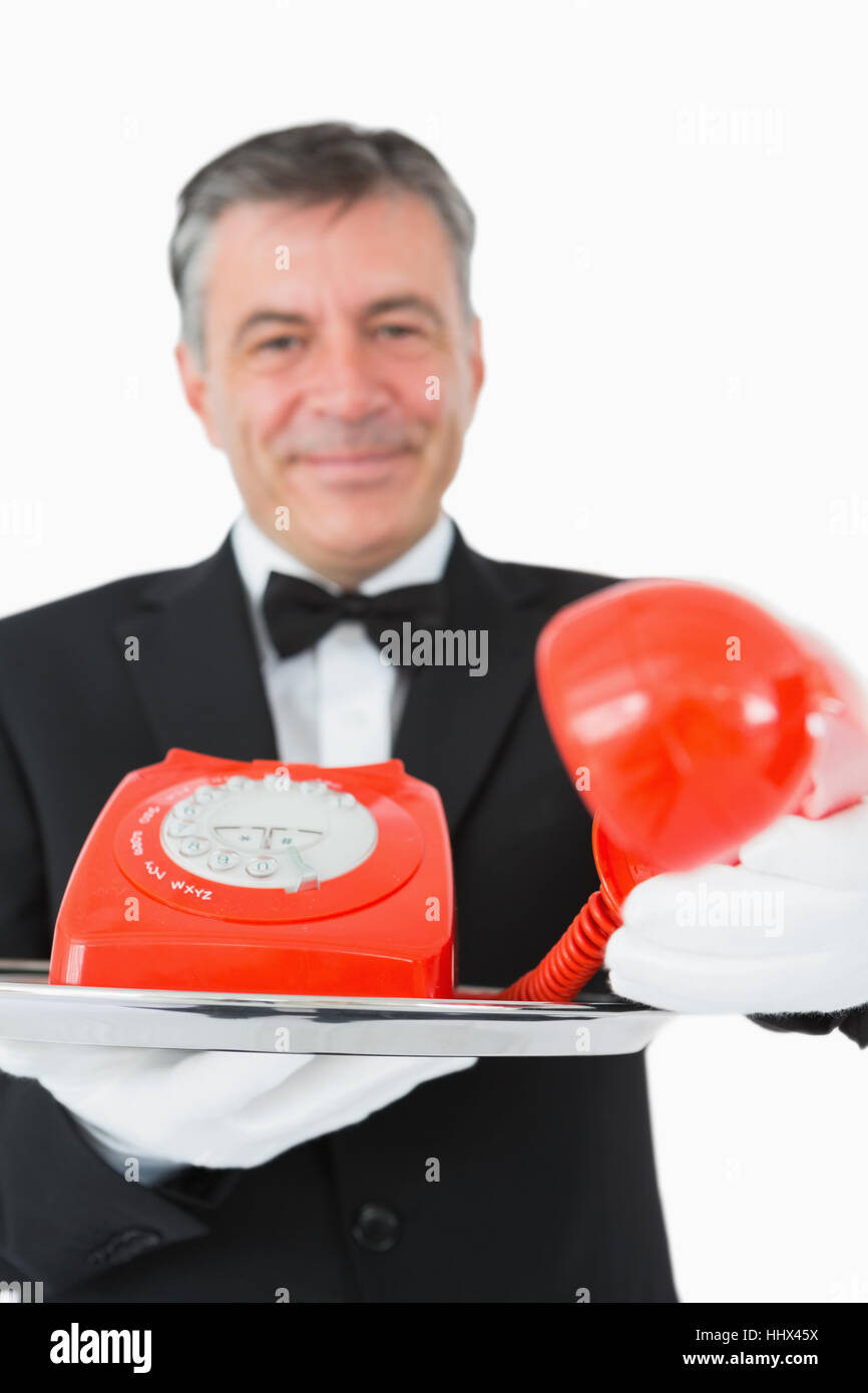 Waiter passing the red phone receiver on a silver tray Stock Photo - Alamy